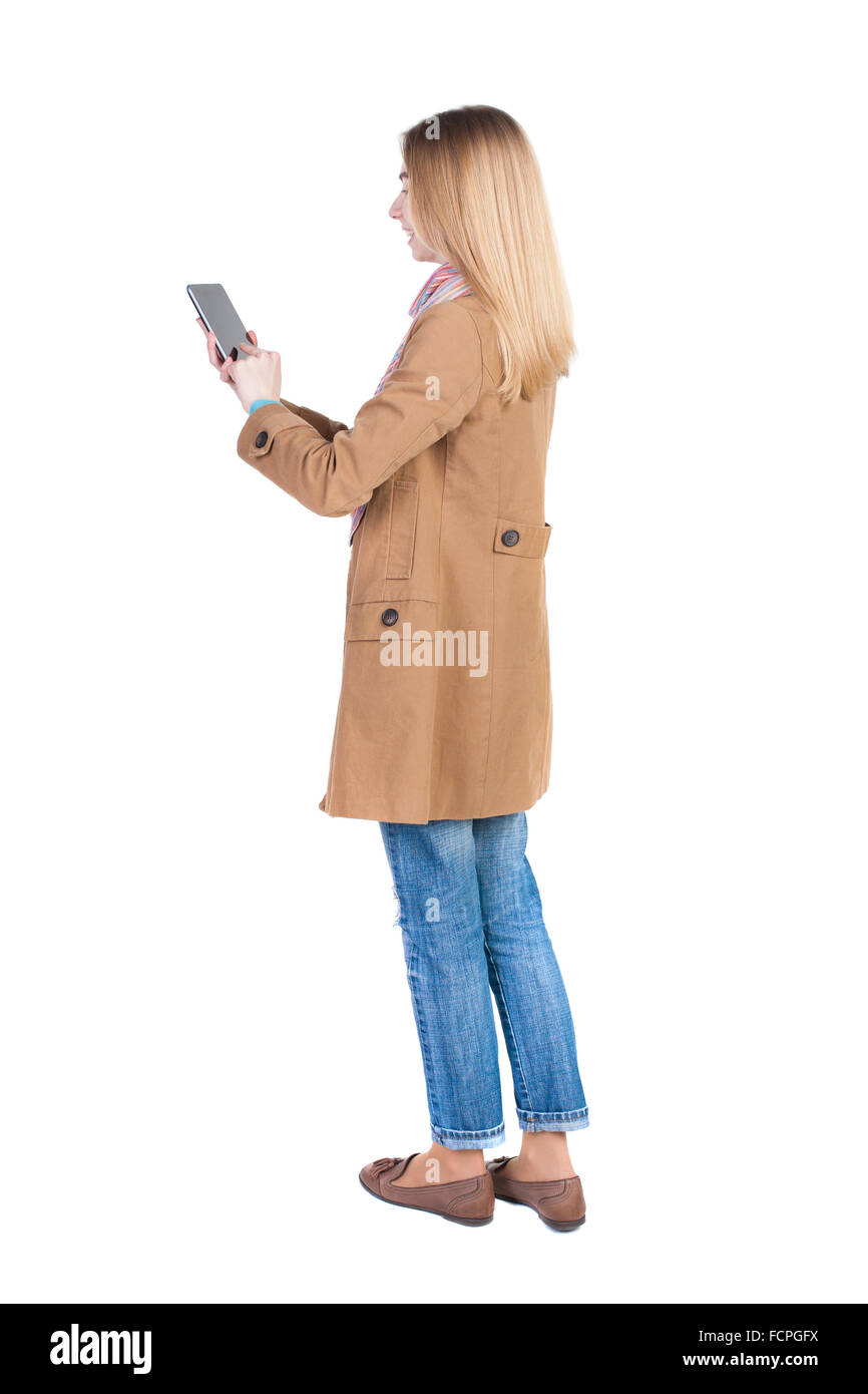 back view of standing young beautiful girl with tablet computer in the ...