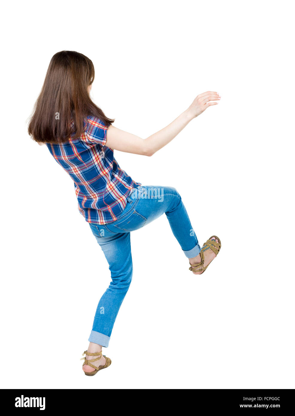 Back view woman Balances waving his arms. Standing young girl in jeans ...