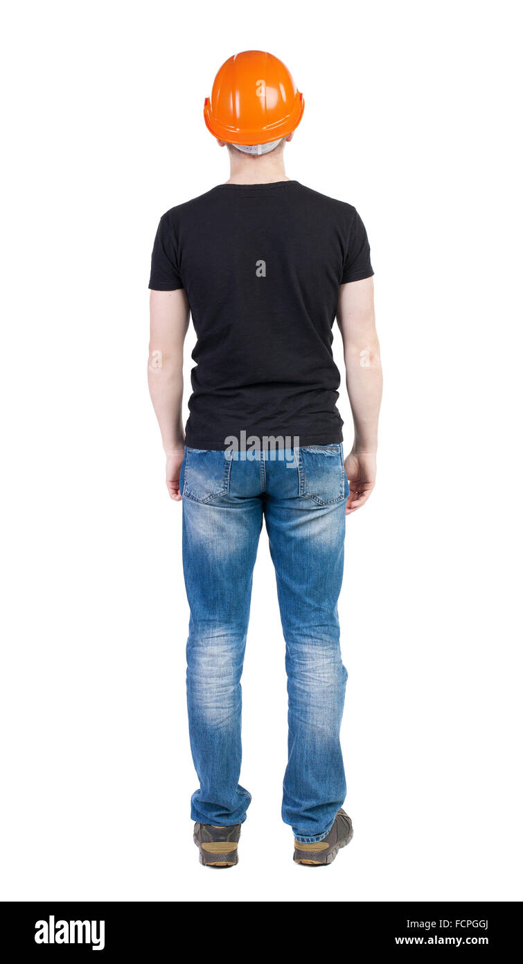 Backview of an engineer in construction helmet stands. Standing young ...