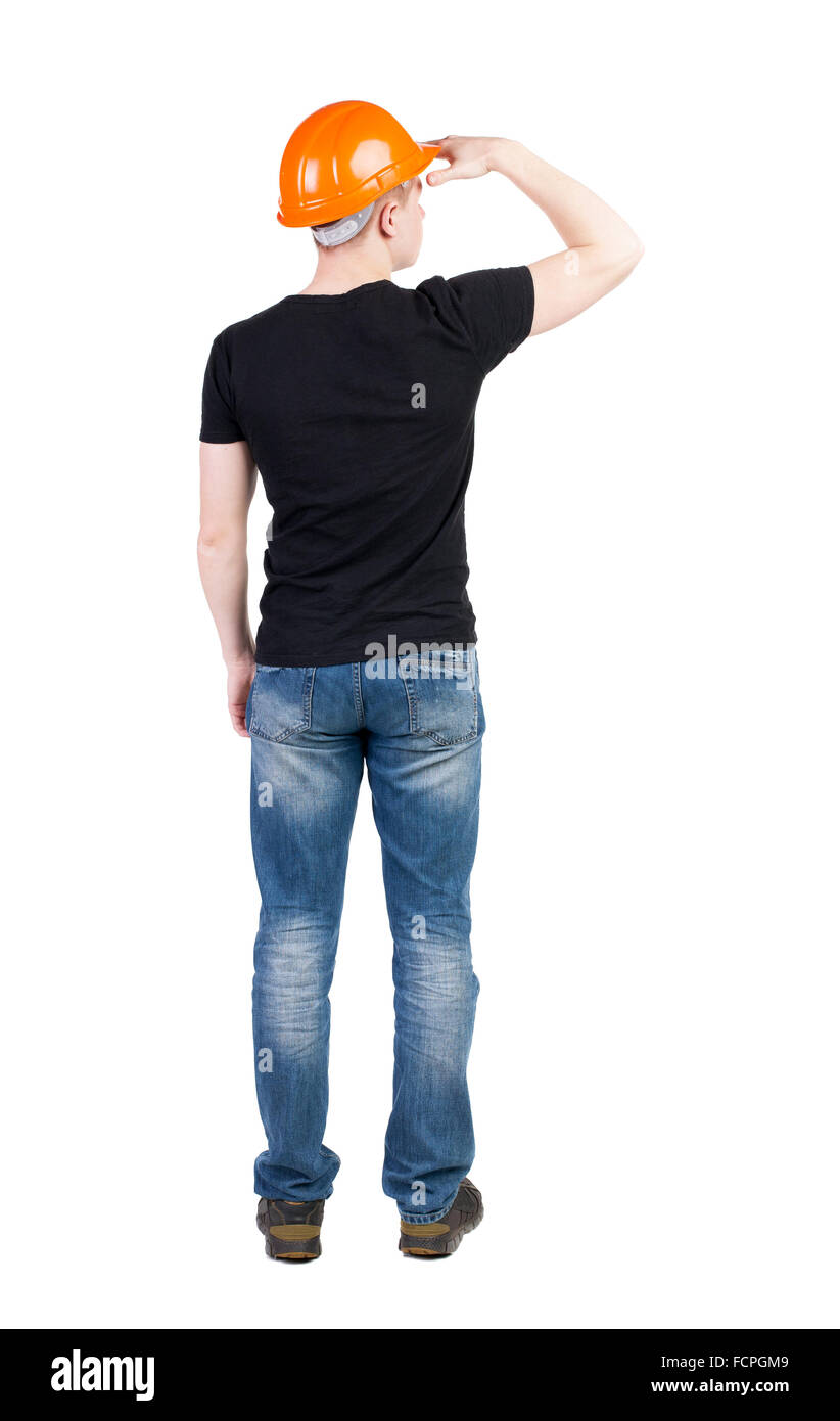Backview of an engineer in construction helmet stands. Standing young ...