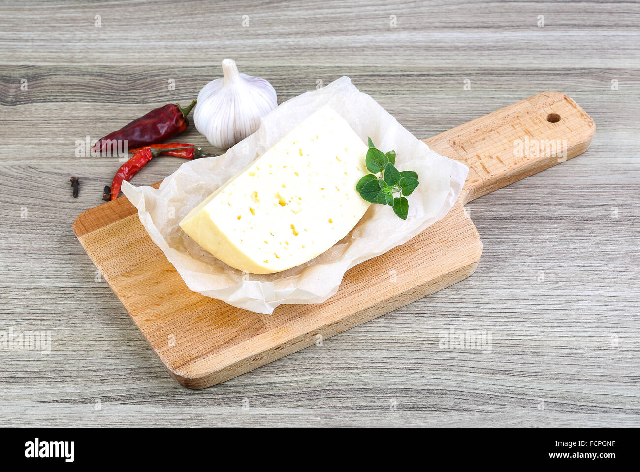 Part of round cheese on the wood background with herbs Stock Photo - Alamy