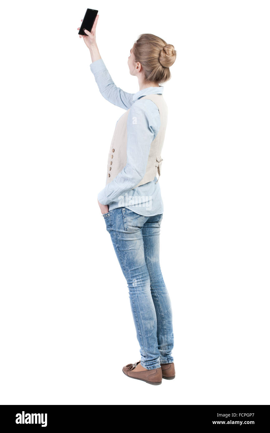 back view of standing young beautiful woman and using a mobile phone ...