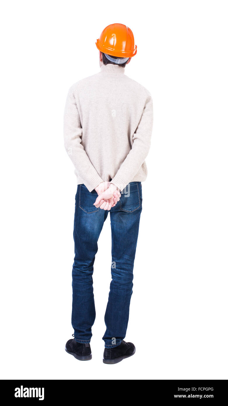 Backview of an engineer in construction helmet stands. Standing young ...