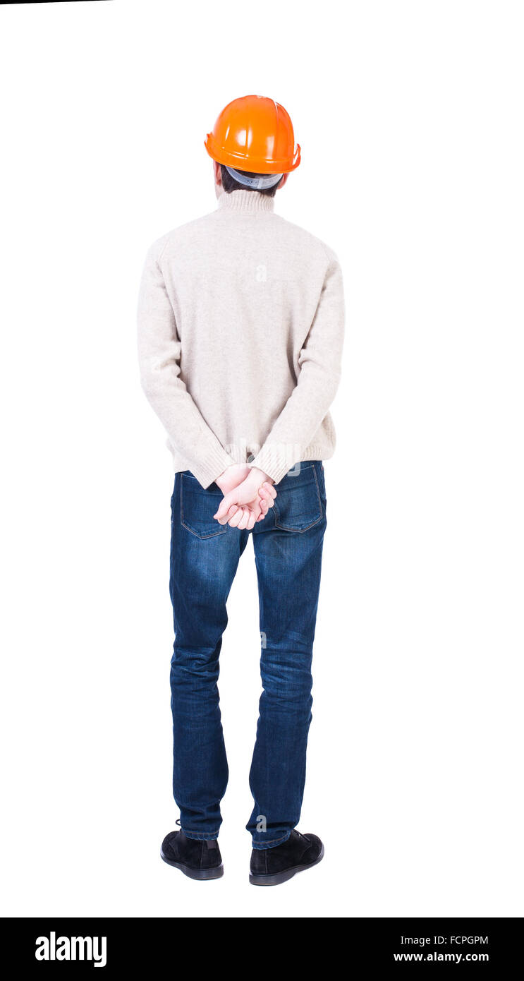 Backview of an engineer in construction helmet stands. Standing young ...