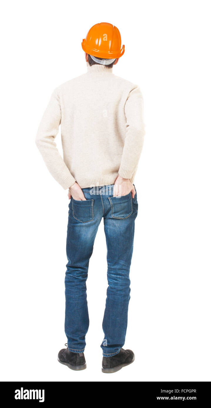 Backview of an engineer in construction helmet stands. Standing young ...