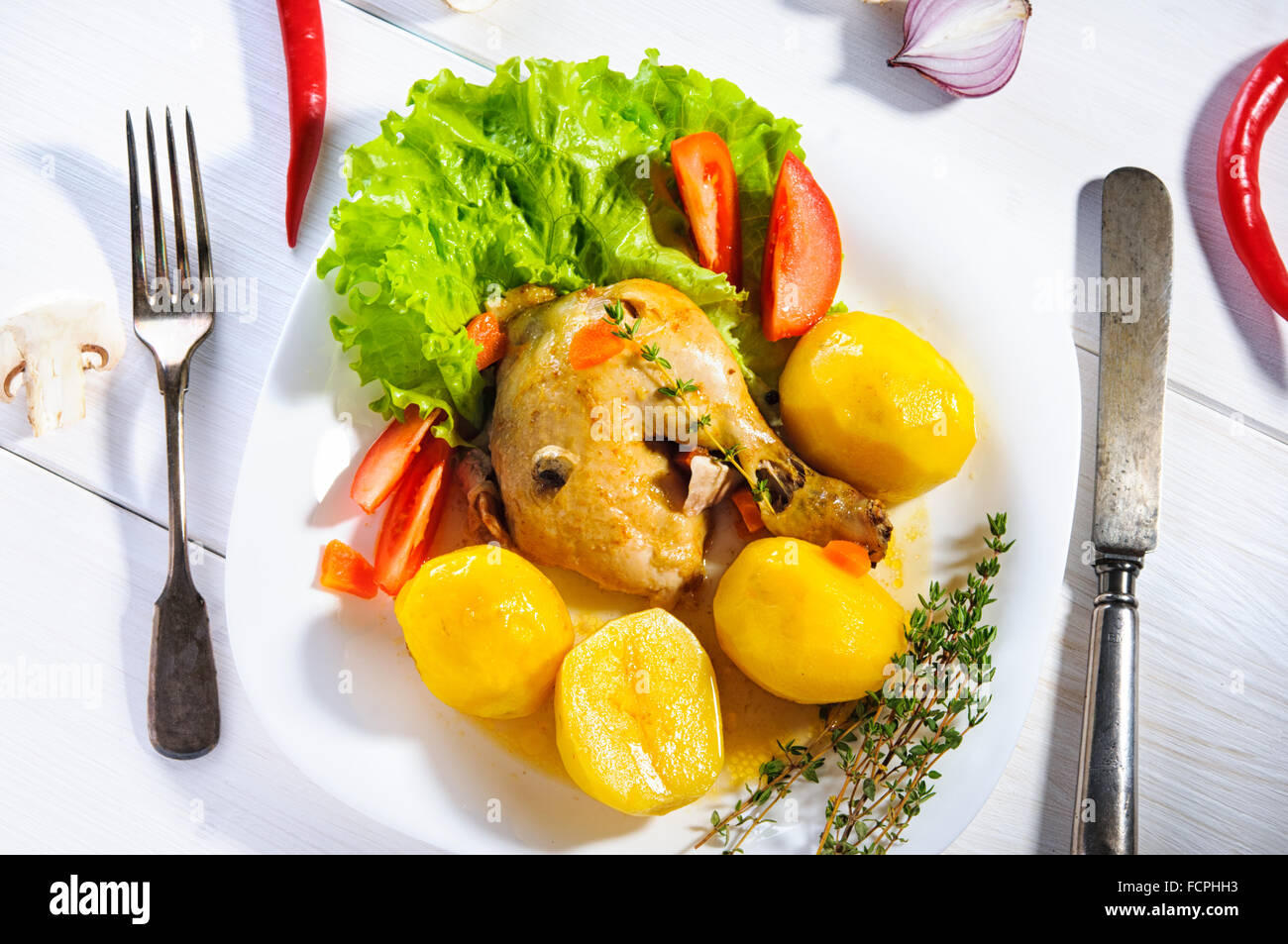Hearty lunch or dinner: plate of chicken leg and potatoes with green ...