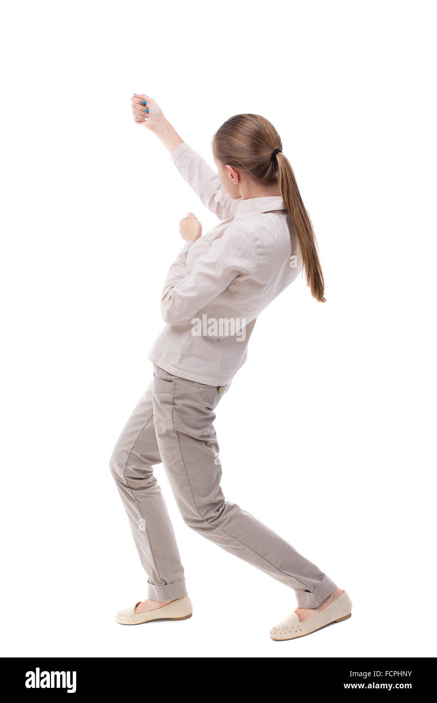 back view of standing girl pulling a rope from the top or cling to ...