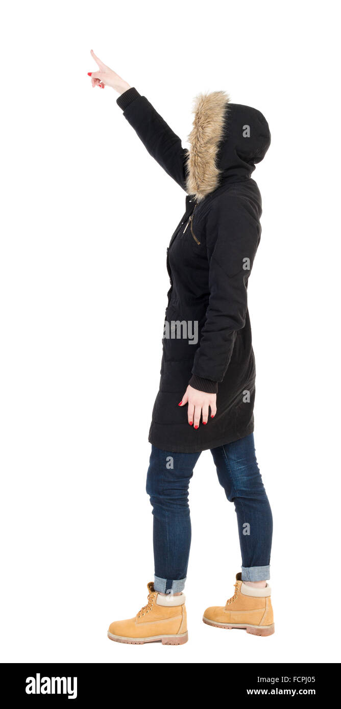 Back view of pointing young women in parka. Young girl gesture. Rear ...
