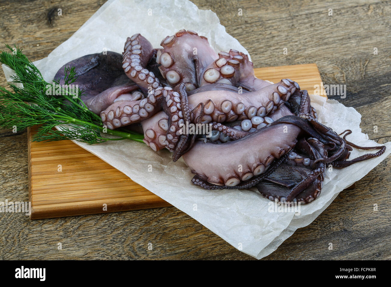 Raw octopus on the wood background ready for cooking Stock Photo - Alamy