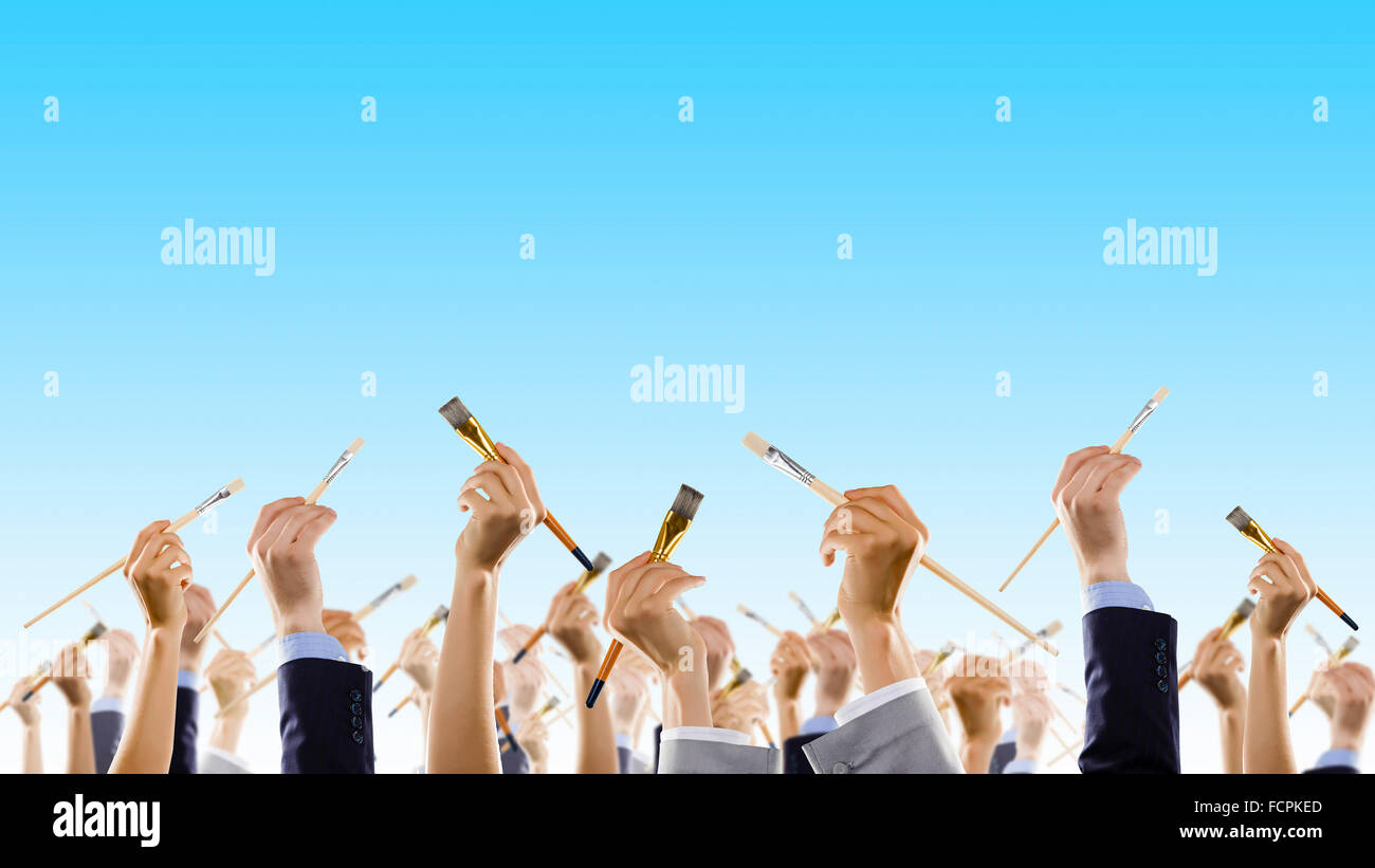 Close up of human hands with paint brushes Stock Photo - Alamy