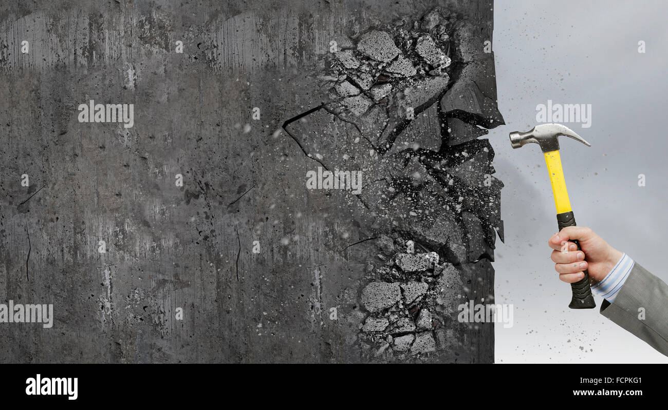 Close up of hammer in hand breaking cement wall Stock Photo - Alamy