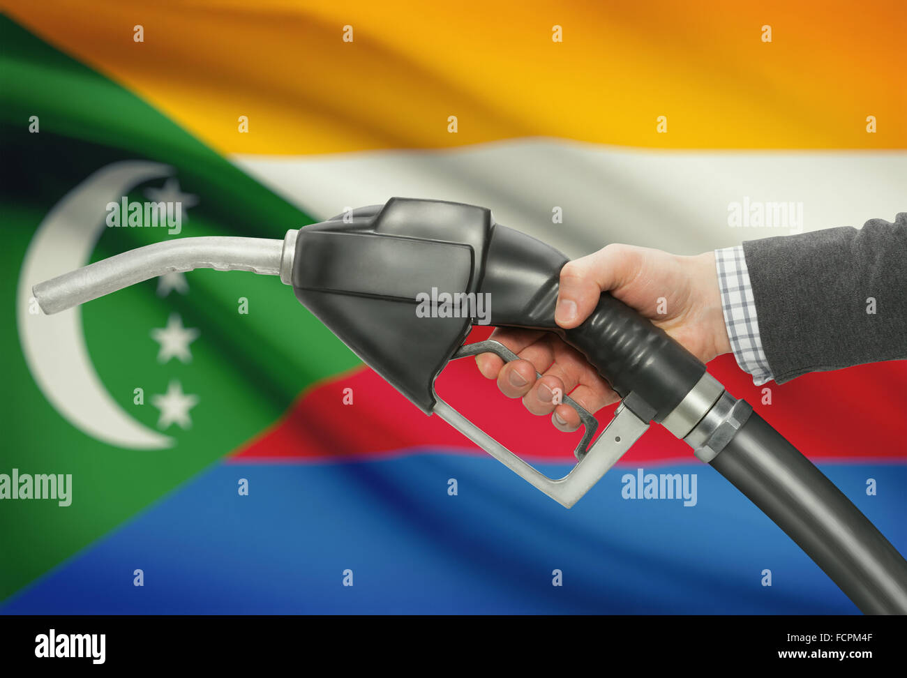 Fuel pump nozzle in hand with flag on background - Comoros Stock Photo ...