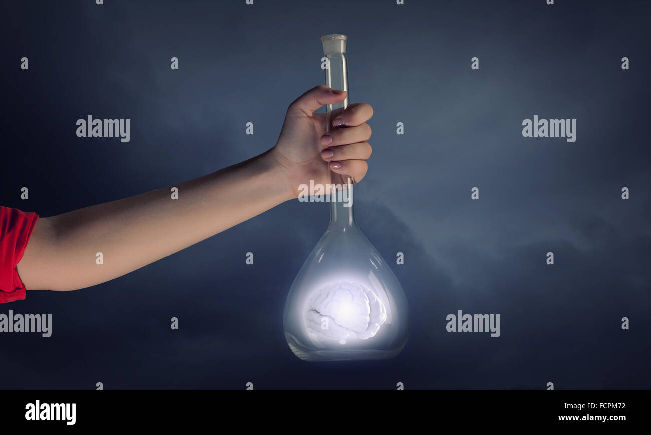 Hand holds flask with images on varied background Stock Photo - Alamy