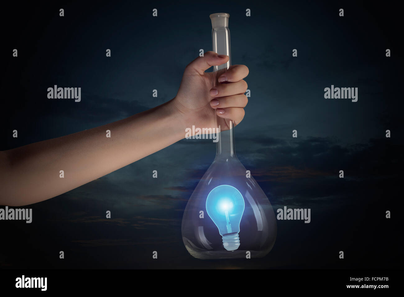 Hand holds flask with images on varied background Stock Photo - Alamy