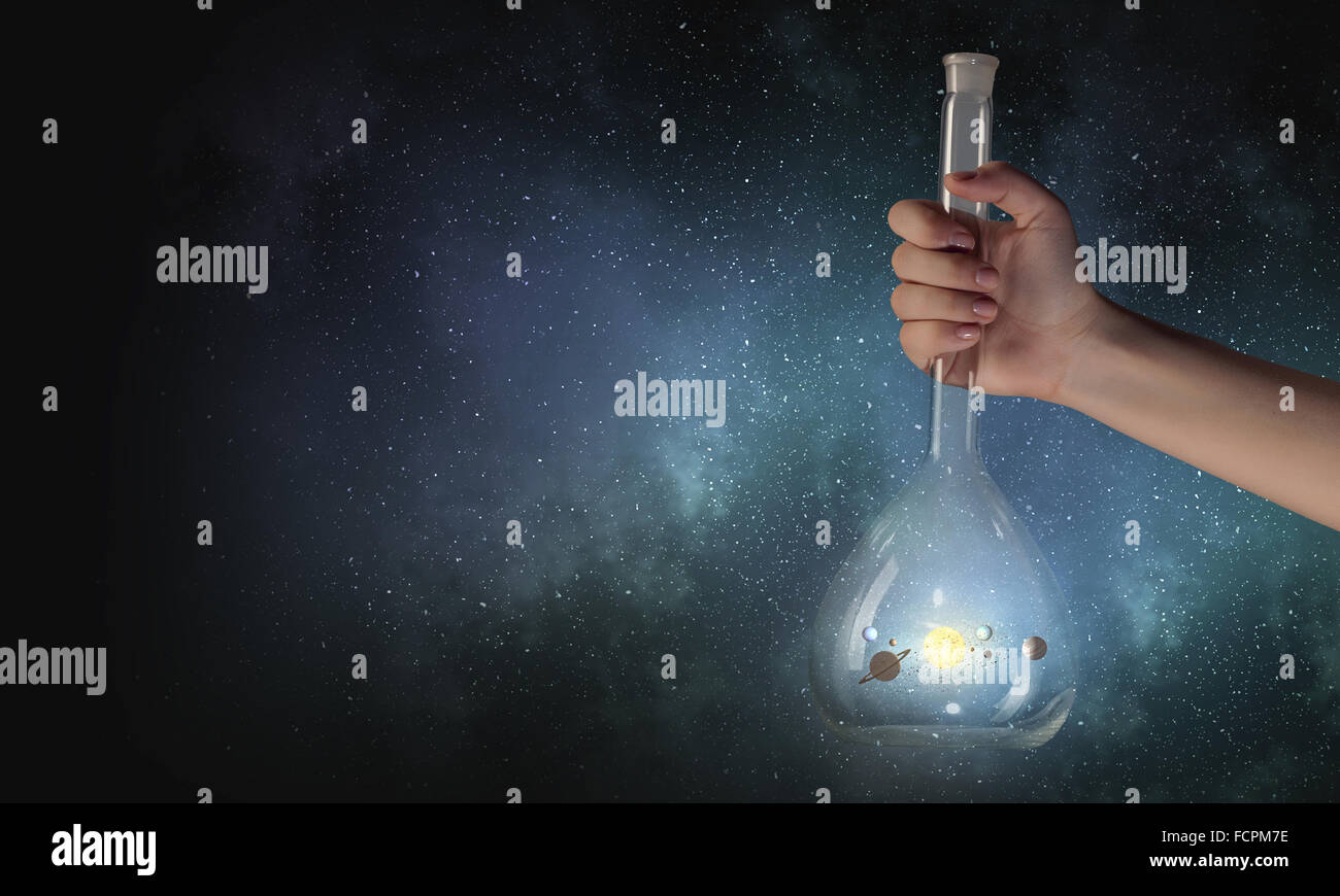 Hand holds flask with images on varied background Stock Photo - Alamy