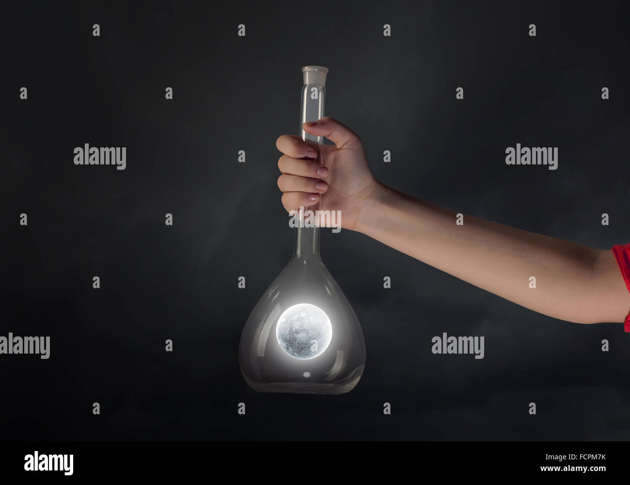 Hand holds flask with images on varied background Stock Photo - Alamy