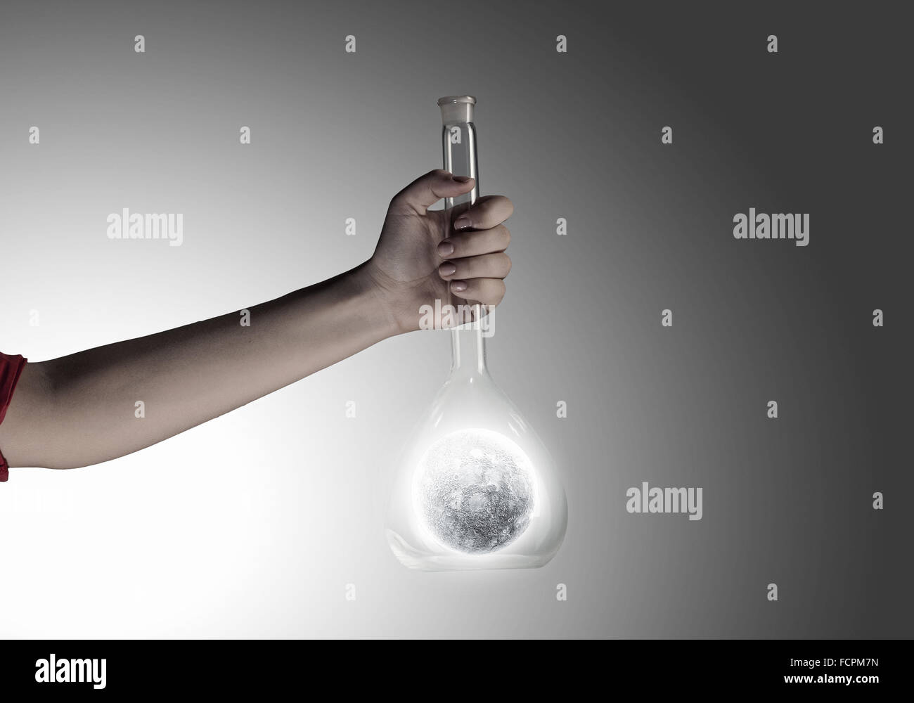 Hand holds flask with images on varied background Stock Photo - Alamy