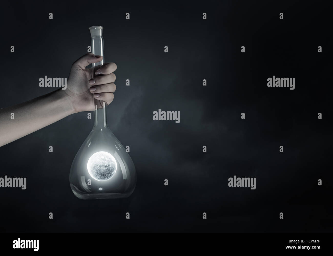 Hand holds flask with images on varied background Stock Photo - Alamy