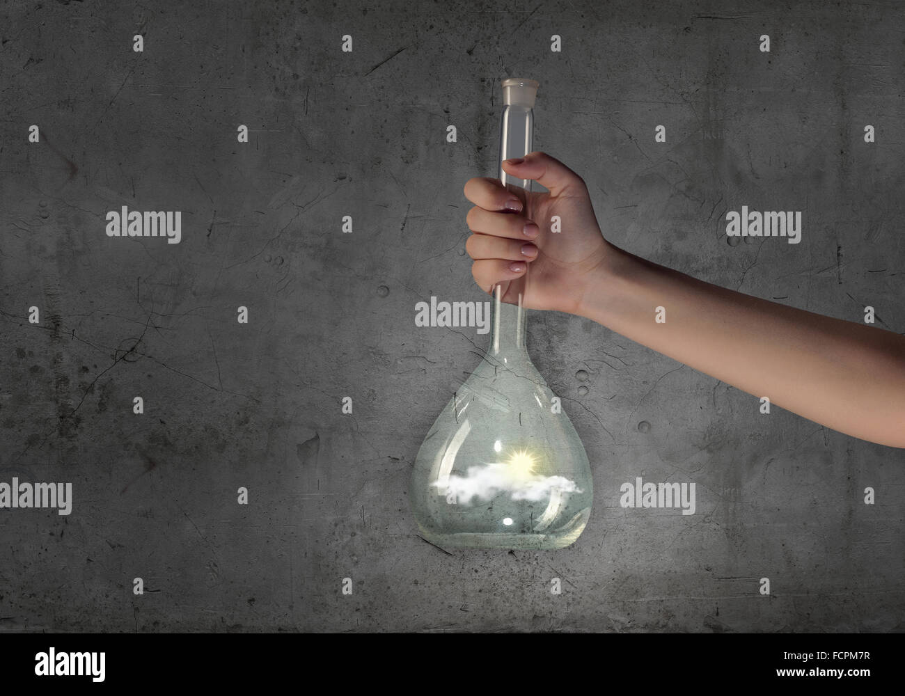 Hand holds flask with images on varied background Stock Photo - Alamy