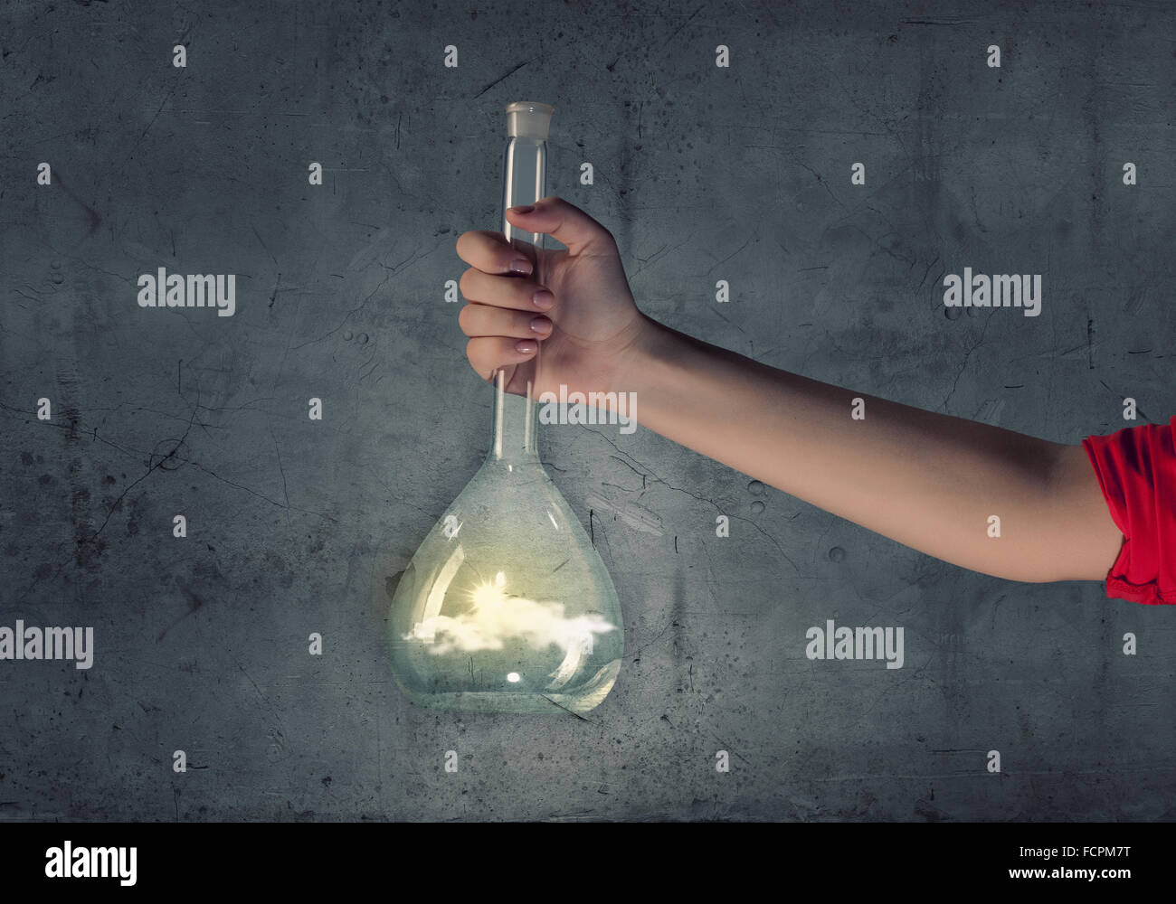 Hand holds flask with images on varied background Stock Photo - Alamy