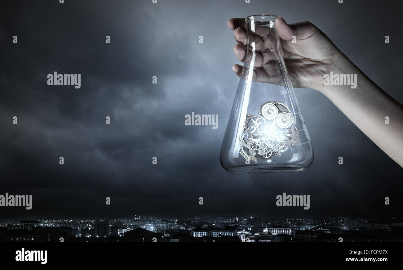 Hand holds flask with images on varied background Stock Photo - Alamy