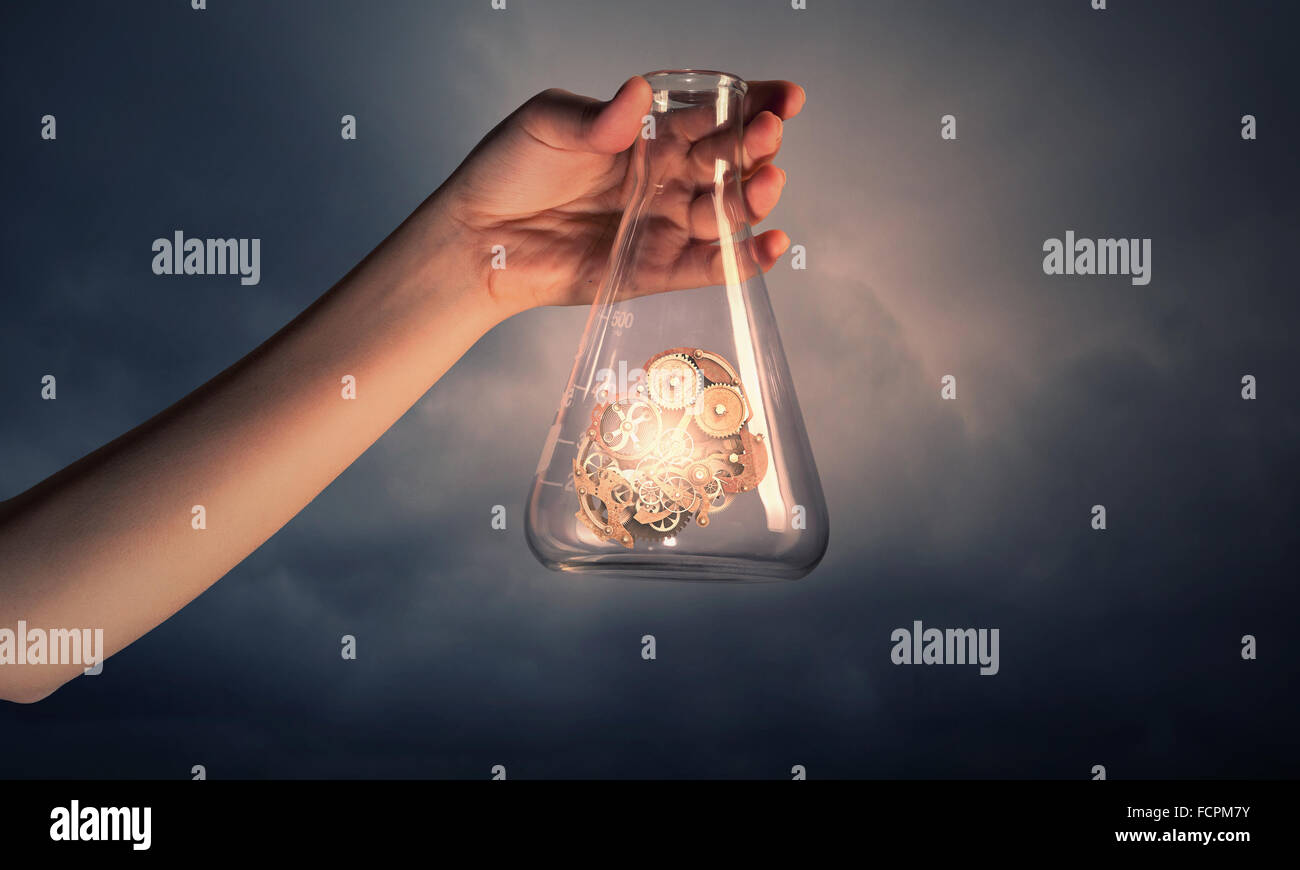 Hand holds flask with images on varied background Stock Photo - Alamy