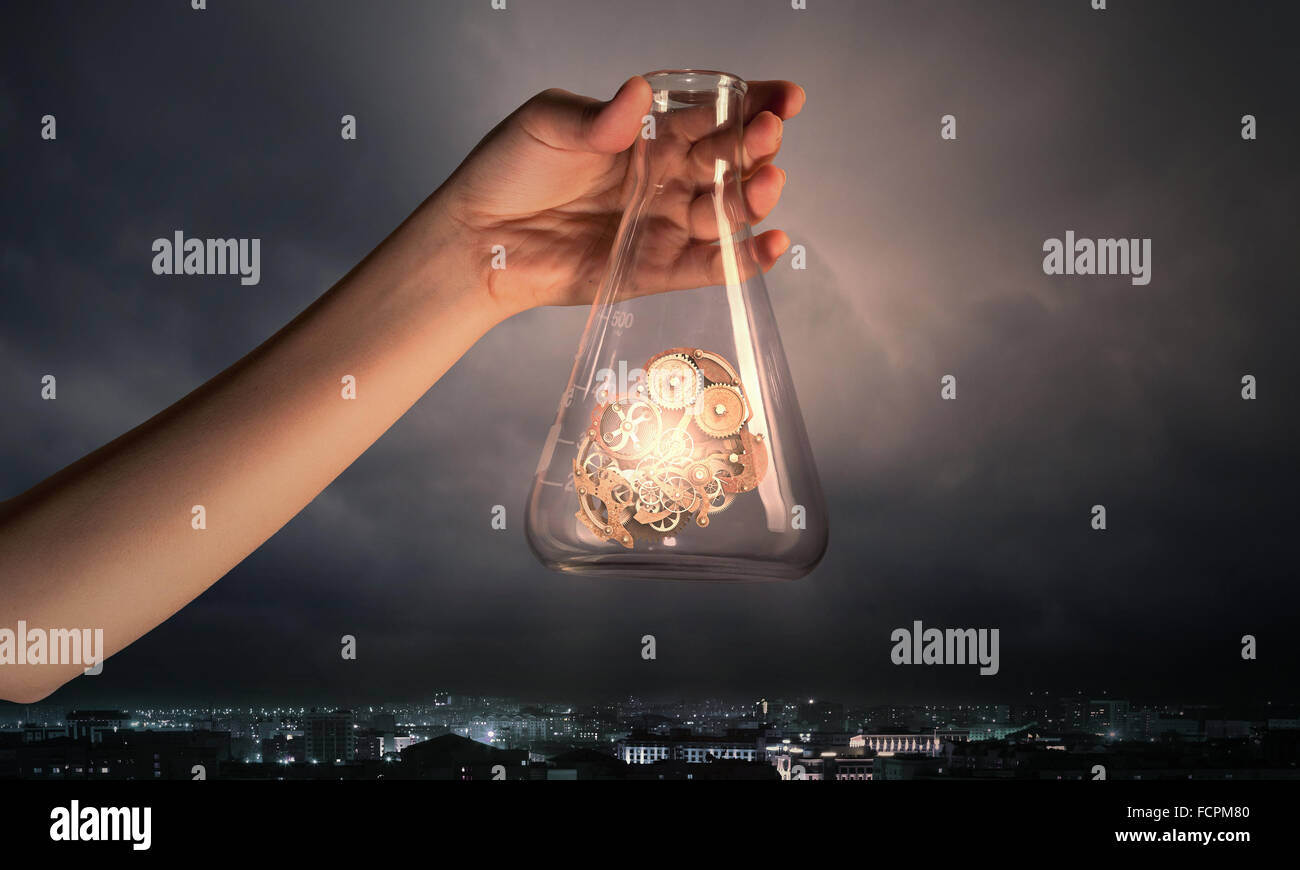 Hand holds flask with images on varied background Stock Photo - Alamy