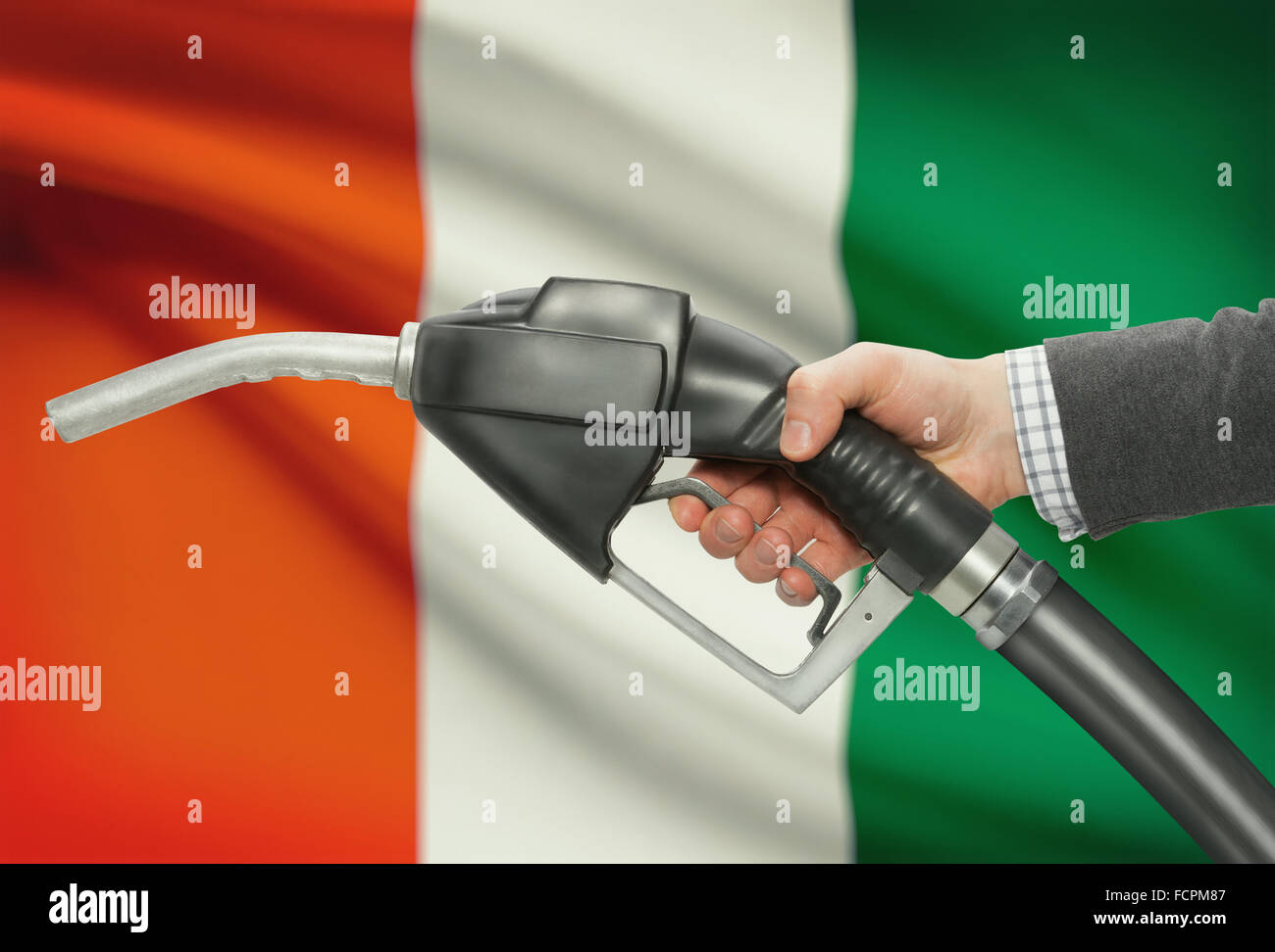 Fuel pump nozzle in hand with flag on background - Ivory Coast Stock ...
