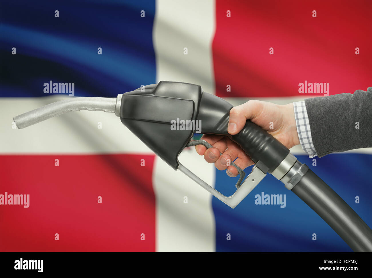 Fuel pump nozzle in hand with flag on background - Dominican Republic ...