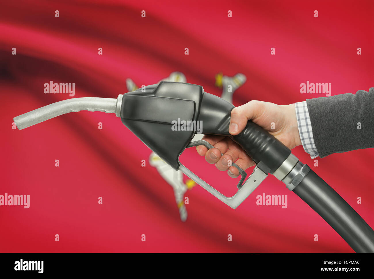 Fuel pump nozzle in hand with flag on background - Isle of Man Stock ...