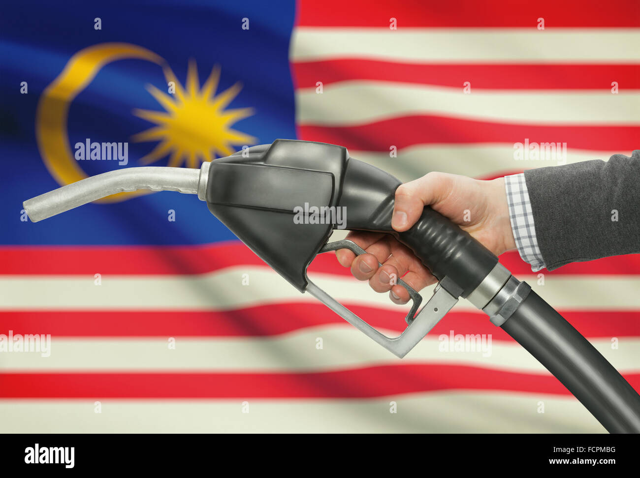 Fuel pump nozzle in hand with flag on background - Malaysia Stock Photo ...