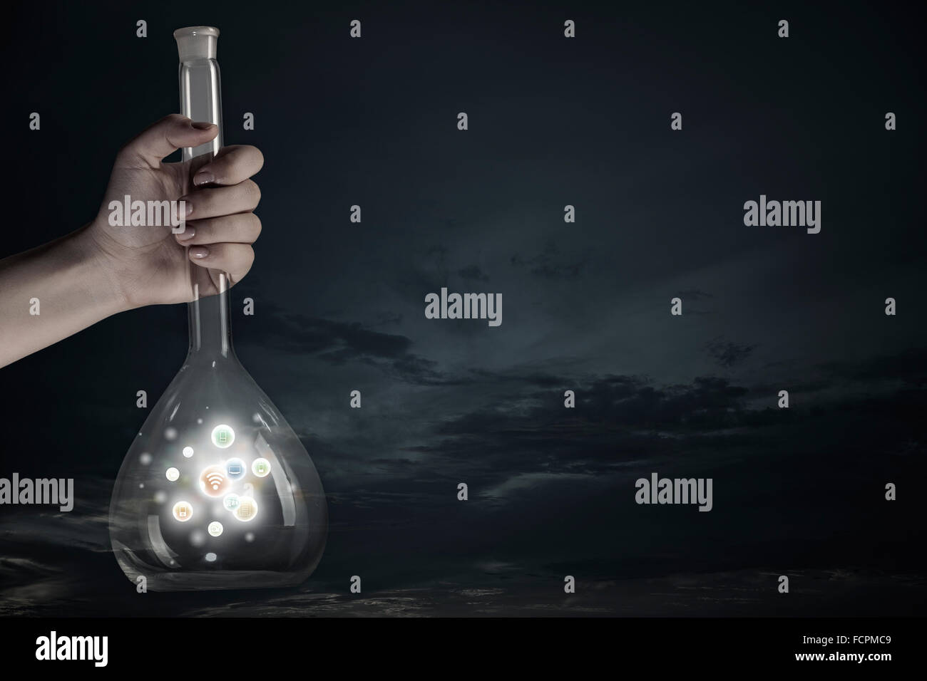 Hand holds flask with images on varied background Stock Photo - Alamy