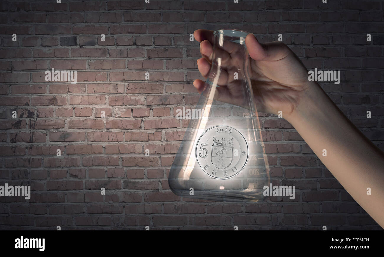 Hand holds flask with images on varied background Stock Photo - Alamy