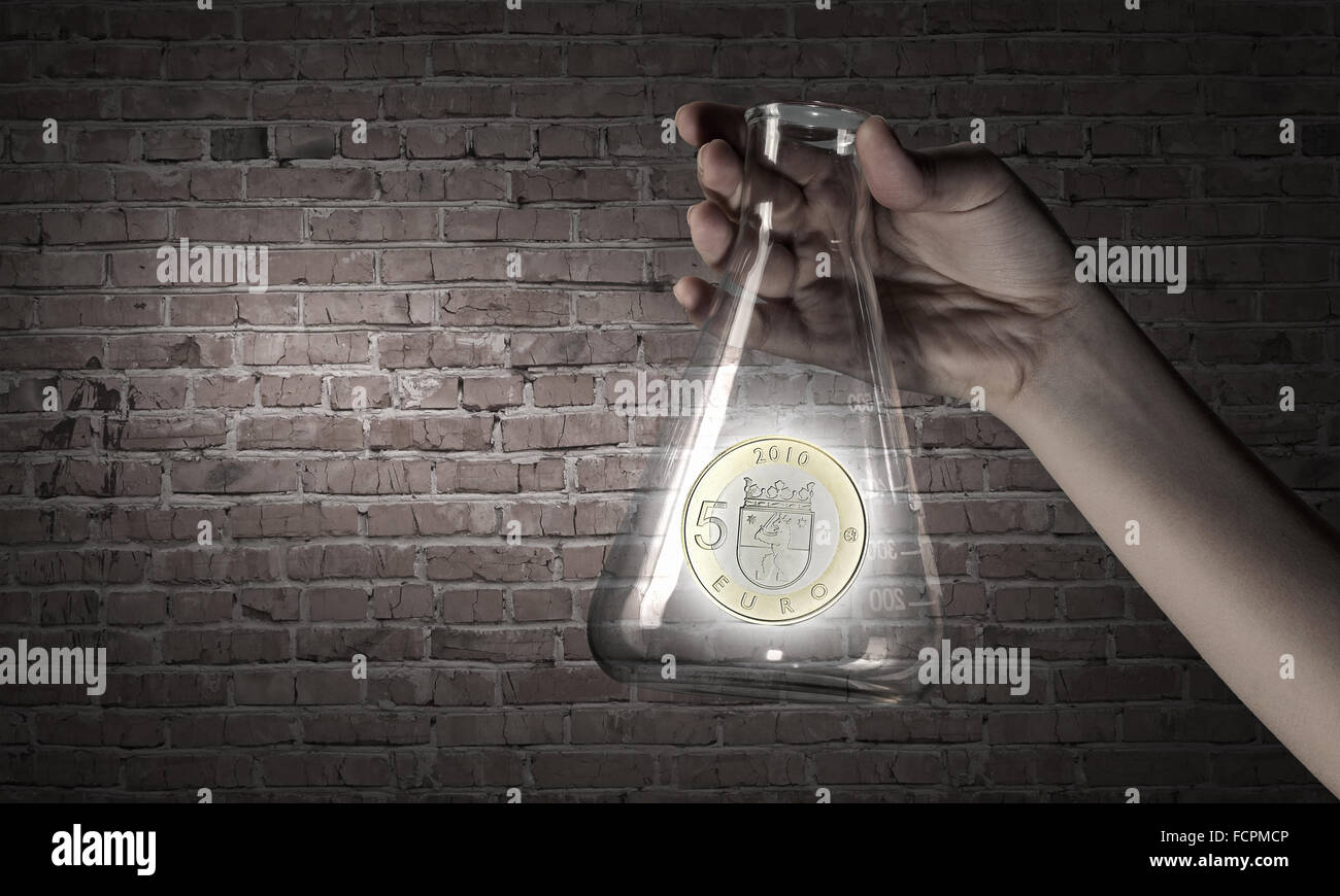 Hand holds flask with images on varied background Stock Photo - Alamy