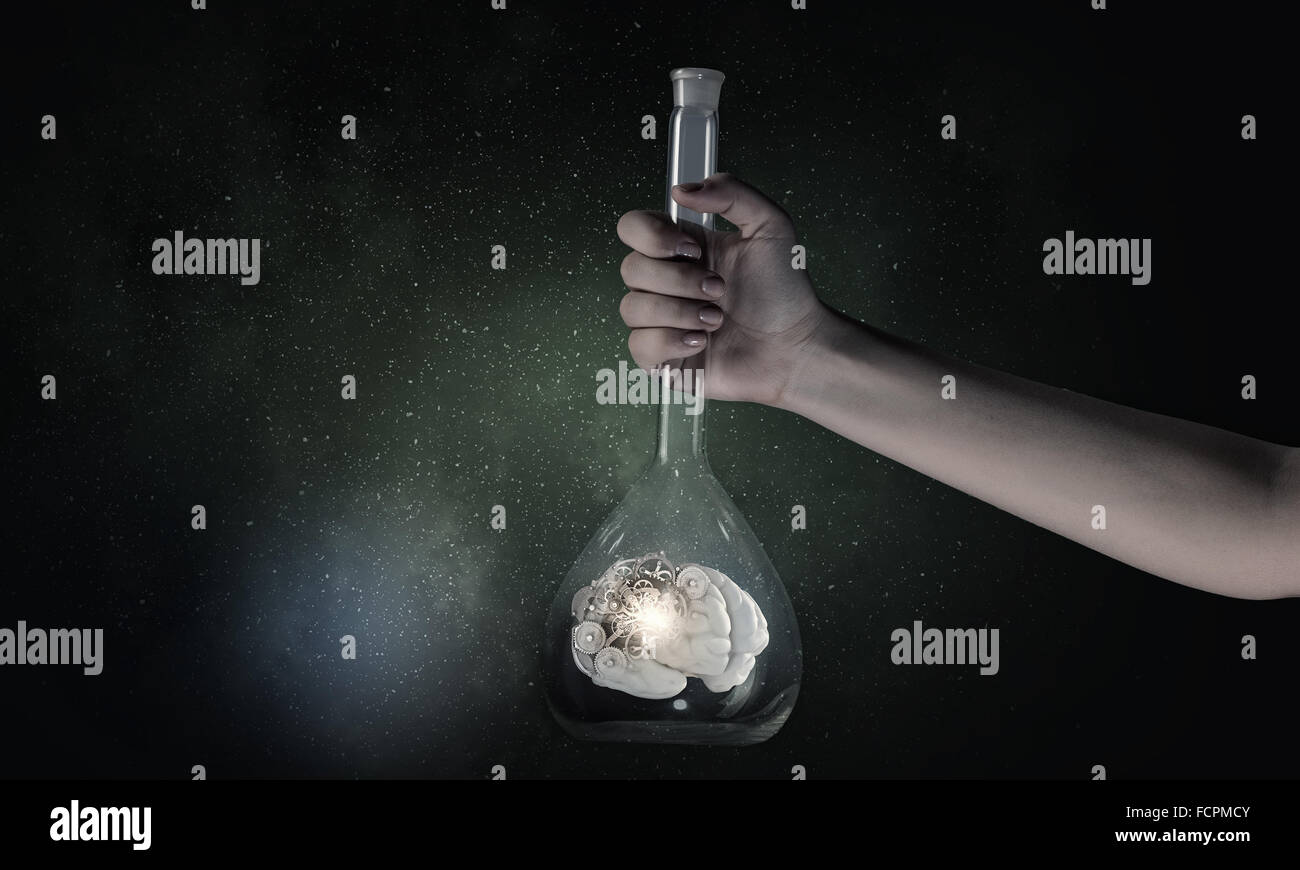 Hand holds flask with images on varied background Stock Photo - Alamy