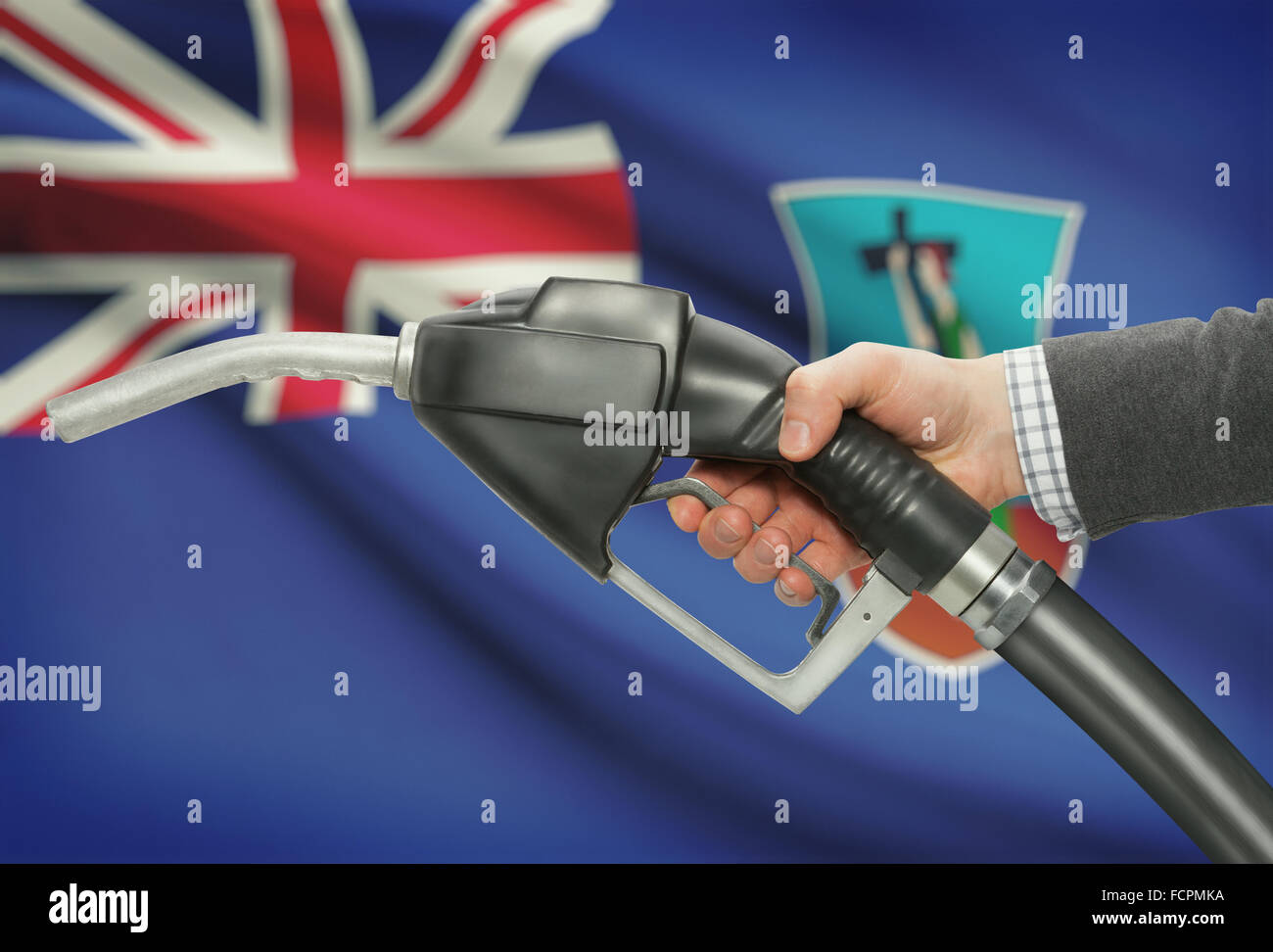 Fuel pump nozzle in hand with flag on background - Montserrat Stock ...