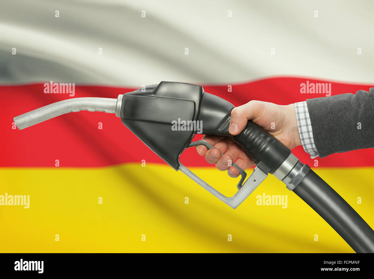 Fuel pump nozzle in hand with flag on background - South Ossetia Stock ...