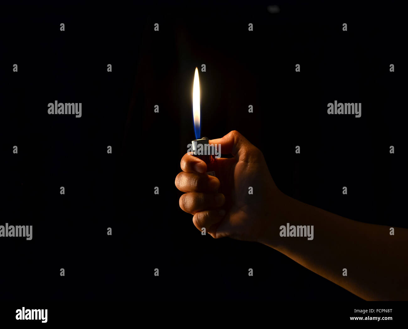 hand hold a lighter in dark background Stock Photo - Alamy