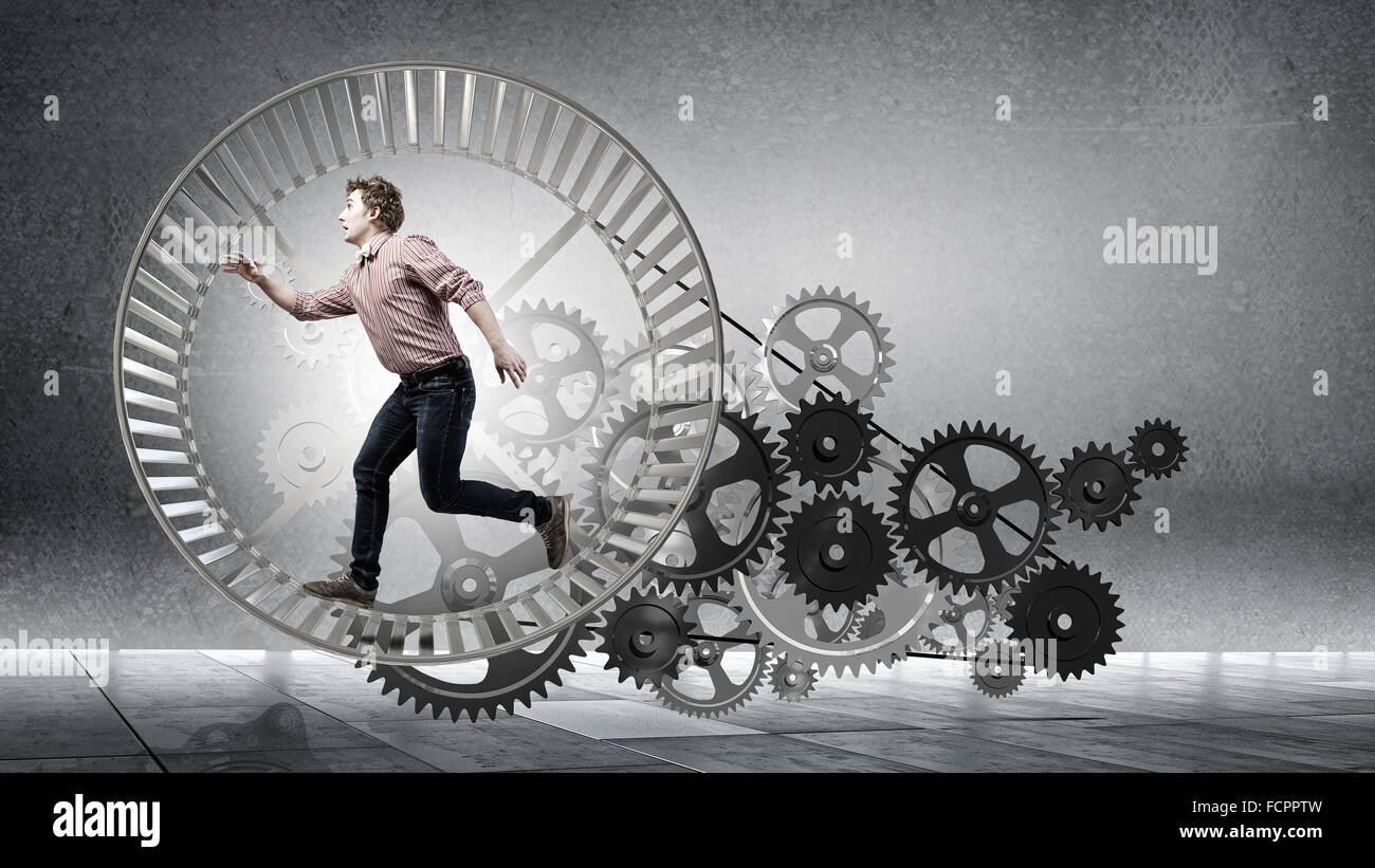 Young businessman running in wheel of gears mechanism Stock Photo - Alamy