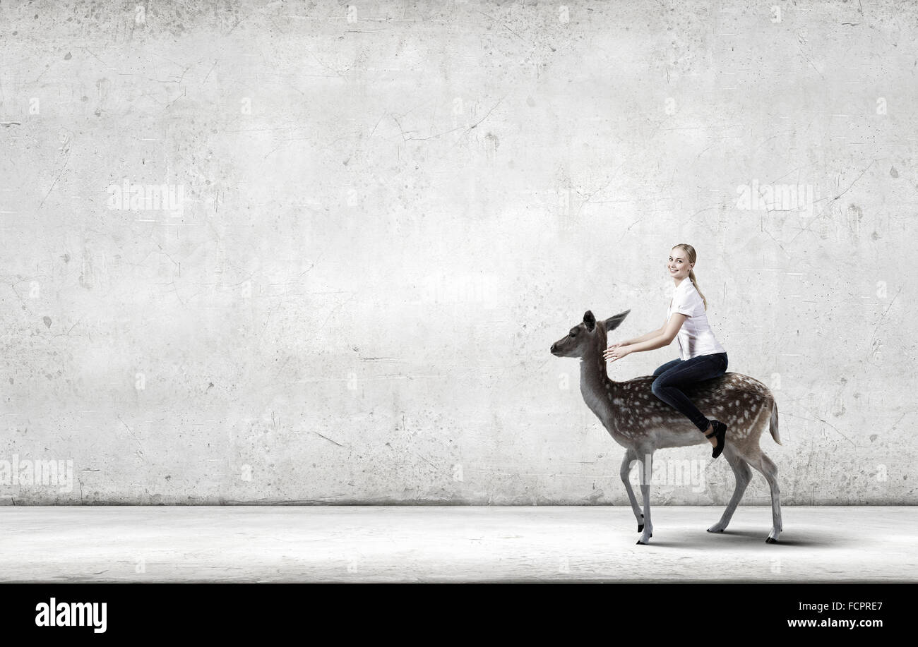Young pretty fearless woman riding deer animal Stock Photo - Alamy