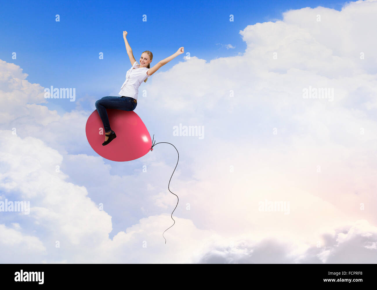 Young woman riding colorful balloon in sky Stock Photo - Alamy