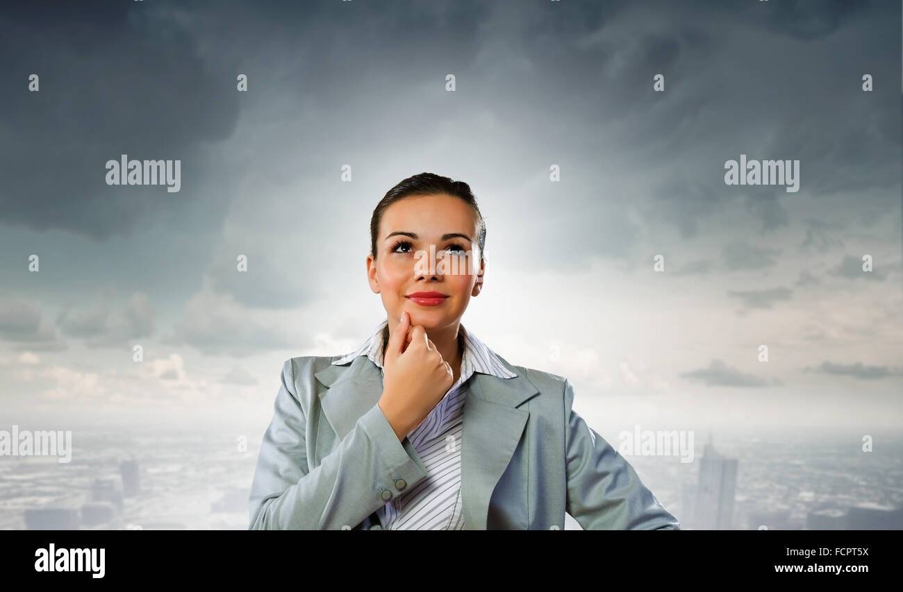 Young pretty businesswoman looking thoughtfully over head Stock Photo ...