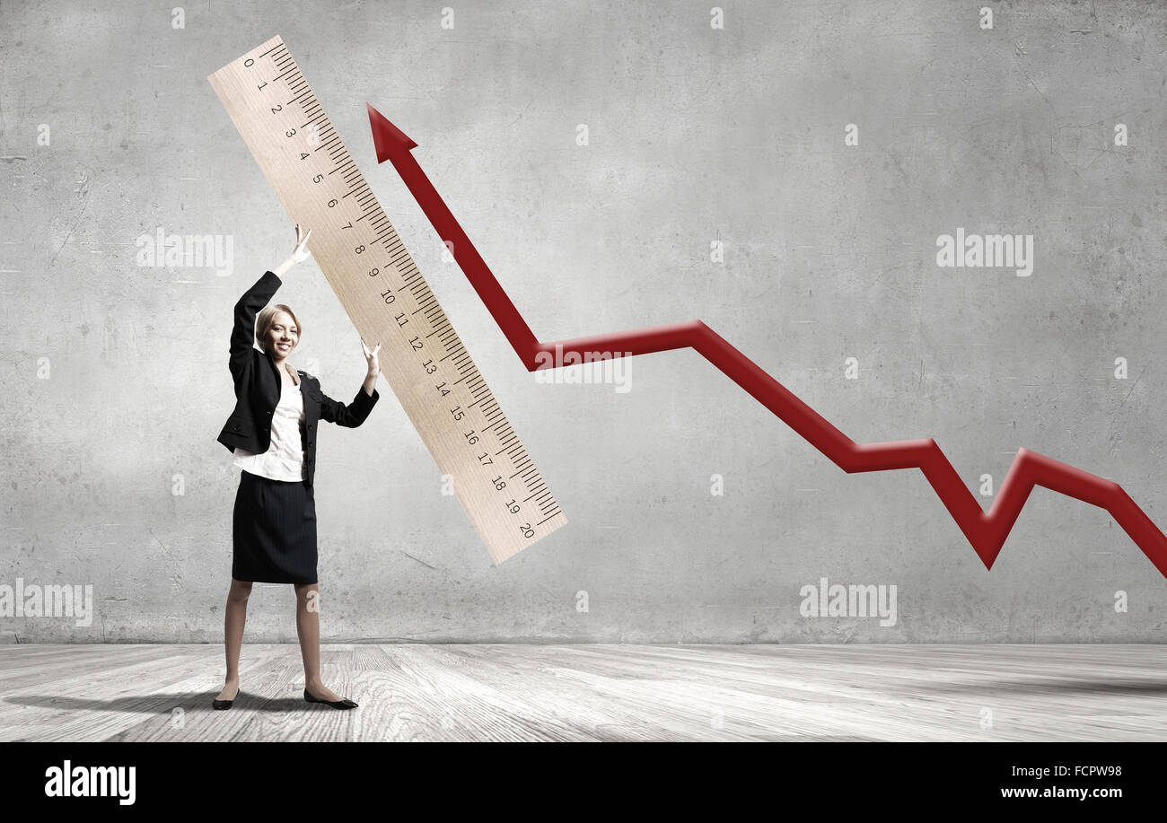 Young businesswoman measuring something with big ruler Stock Photo - Alamy