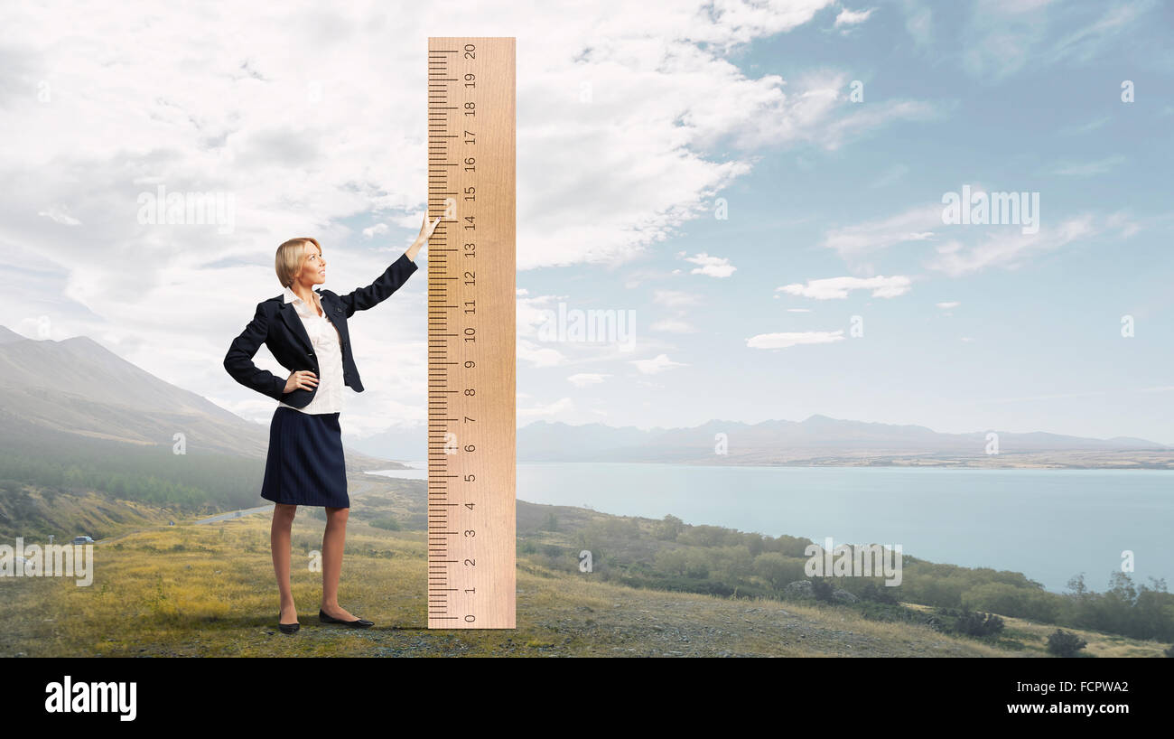 Young businesswoman measuring something with big ruler Stock Photo - Alamy