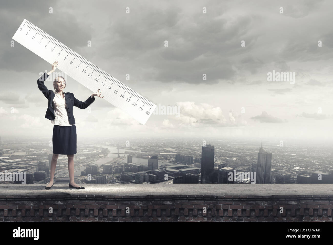 Young businesswoman measuring something with big ruler Stock Photo - Alamy