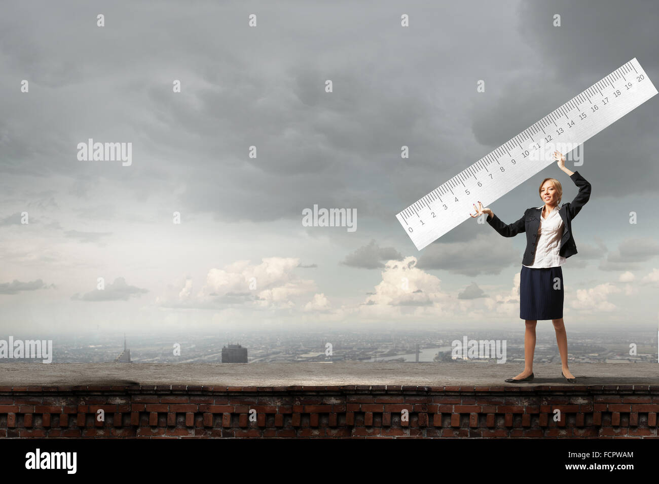 Young businesswoman measuring something with big ruler Stock Photo - Alamy