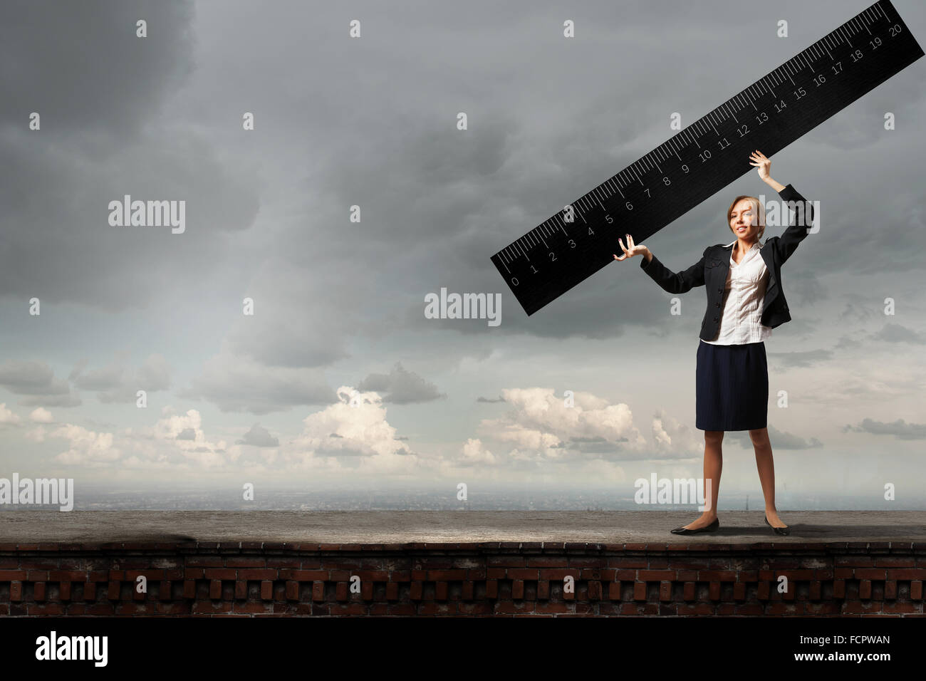 Young businesswoman measuring something with big ruler Stock Photo - Alamy