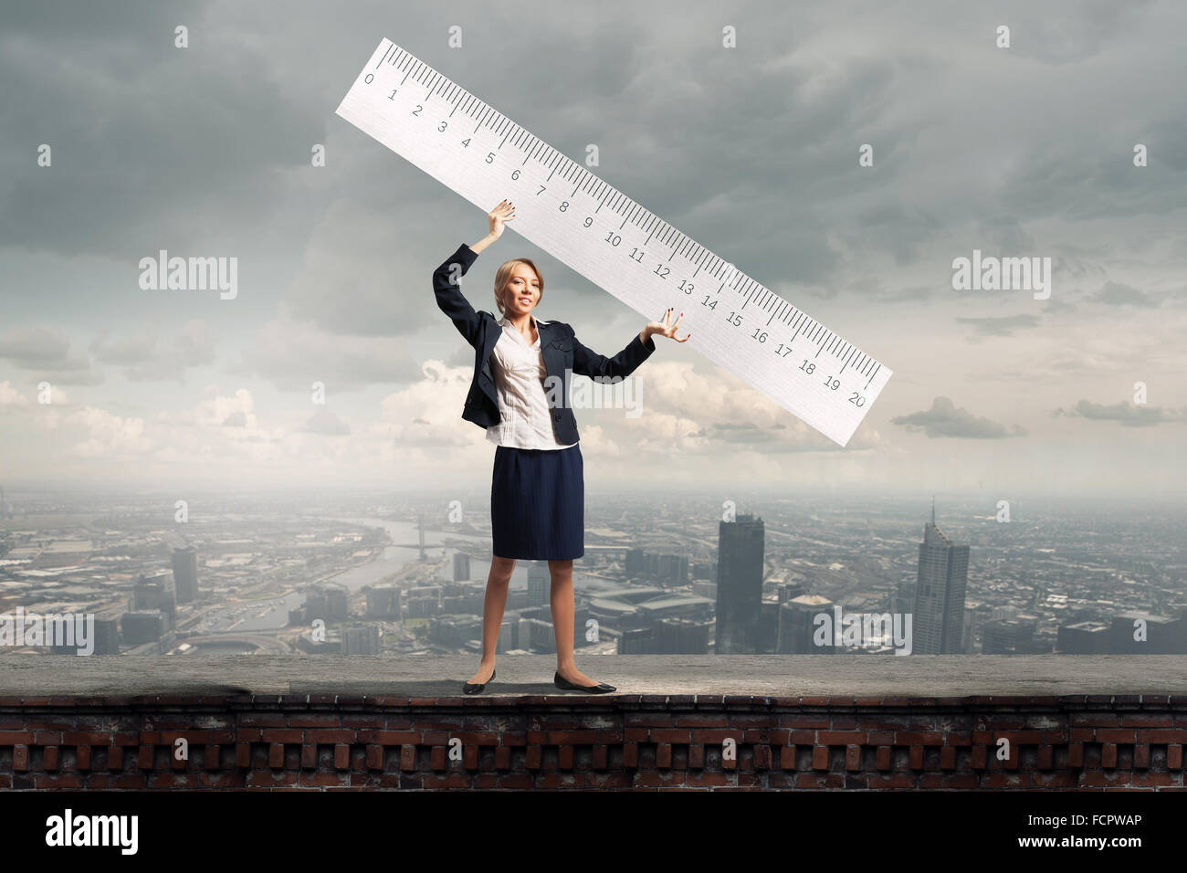 Young businesswoman measuring something with big ruler Stock Photo - Alamy