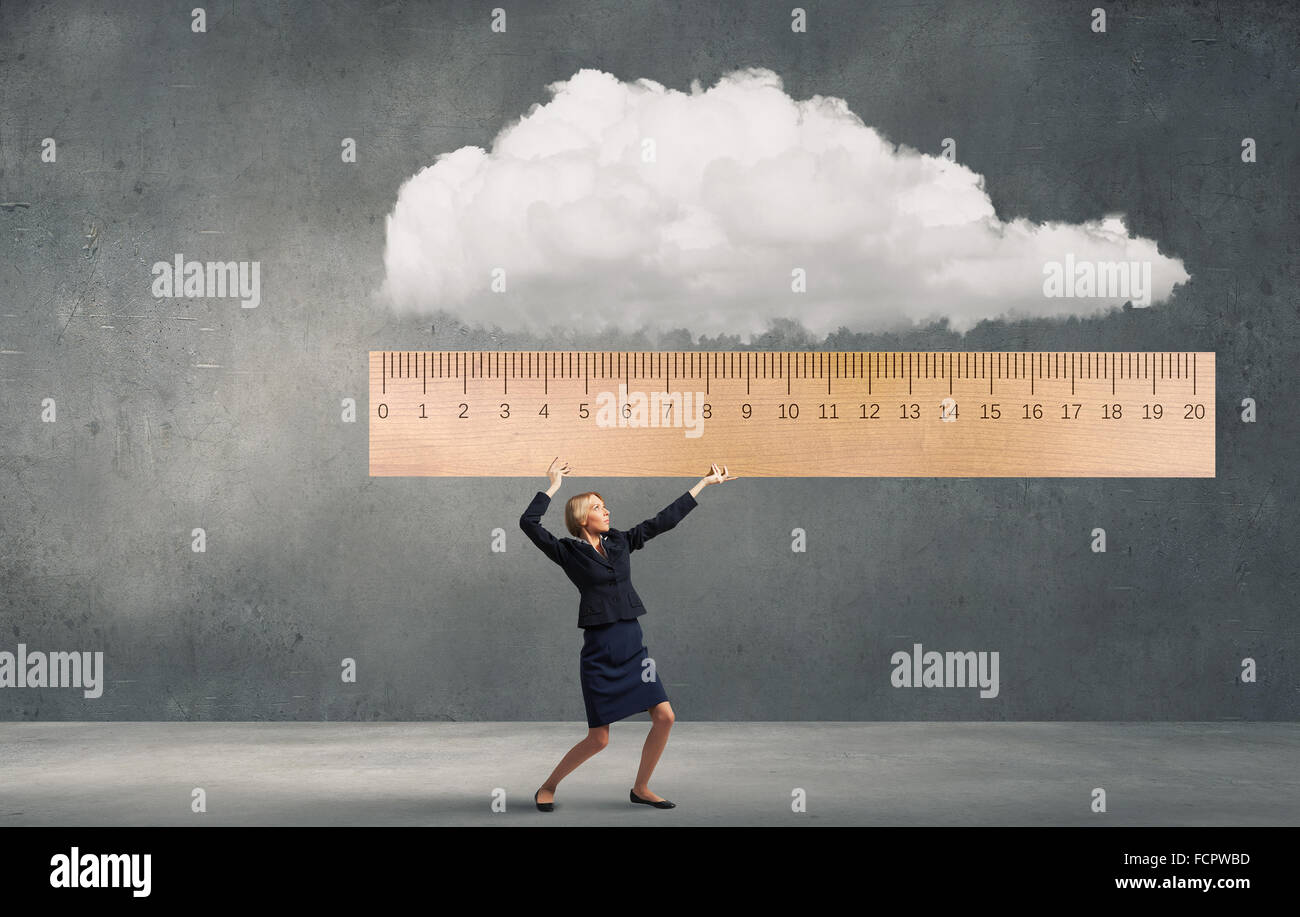 Young businesswoman measuring something with big ruler Stock Photo - Alamy