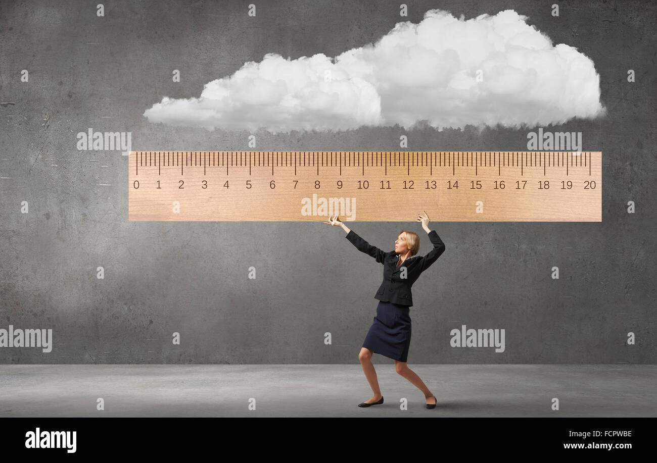 Young businesswoman measuring something with big ruler Stock Photo - Alamy